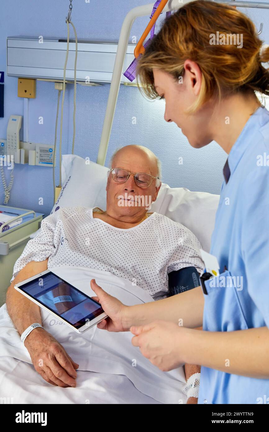 Nurse reading with the tablet the identification bracelet of a patient ...