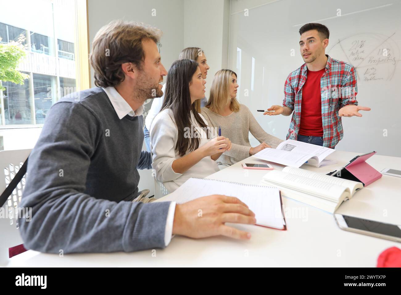 Teacher with group of students doing a joint work, University of the ...