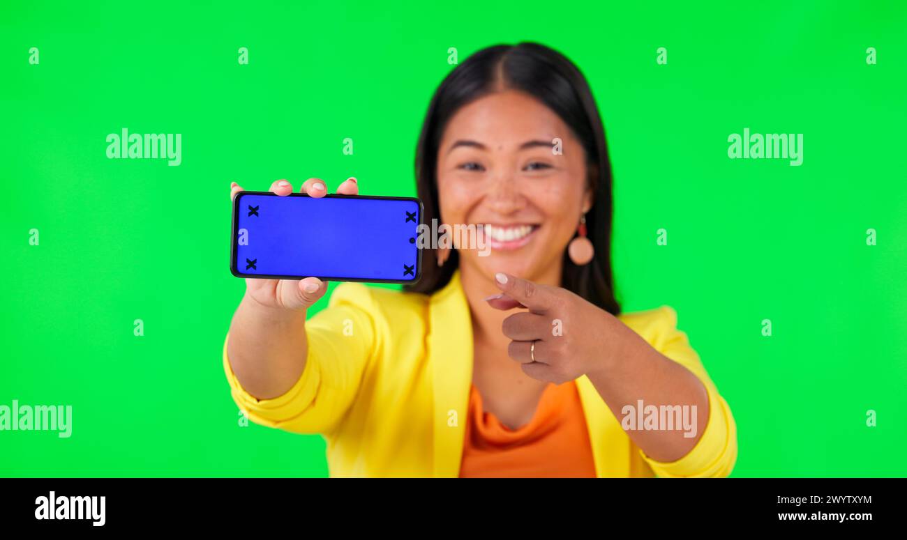 Woman face, green screen and hand pointing to phone mockup with ...