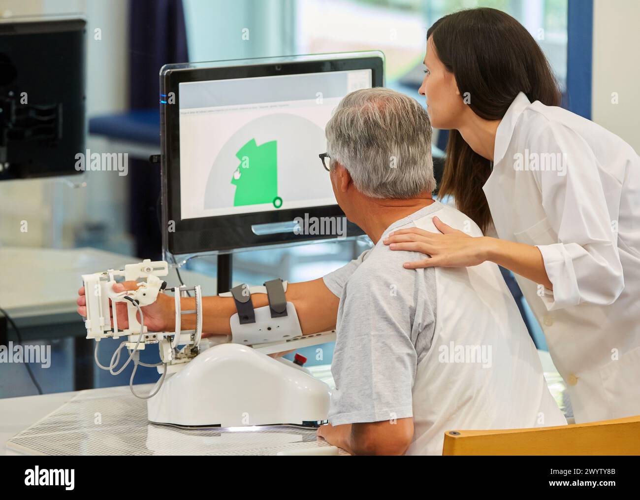 Therapist and patient with assistive robot for upper limb ...