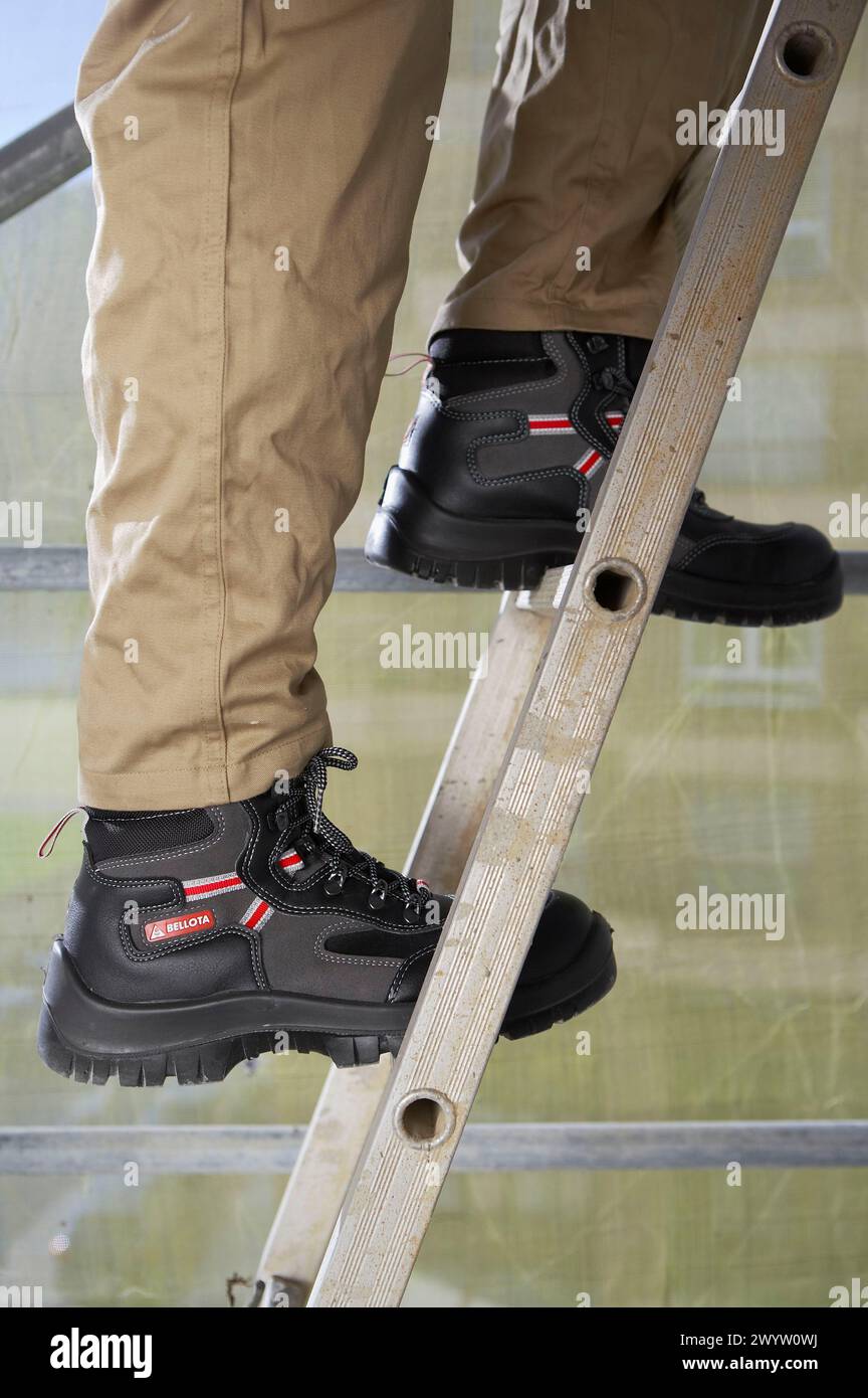 Bricklayer with safety boots, ladder, housing construction Stock Photo ...