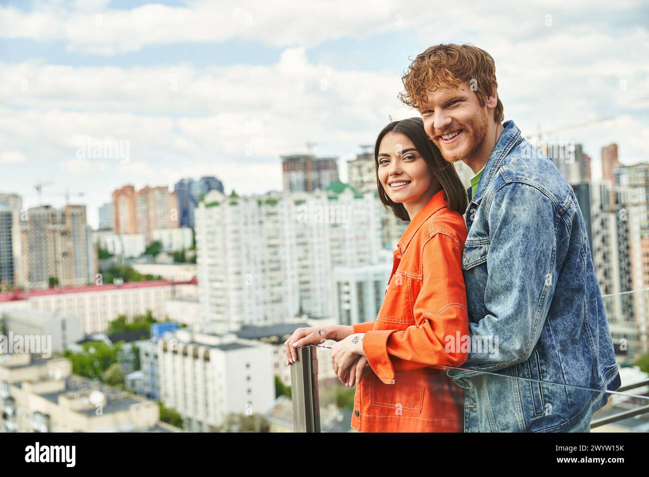 A man and a woman stand side by side, both looking towards the horizon ...