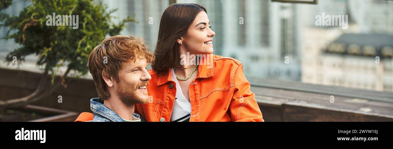 A man and a woman sit closely together on a park bench, engaging in ...