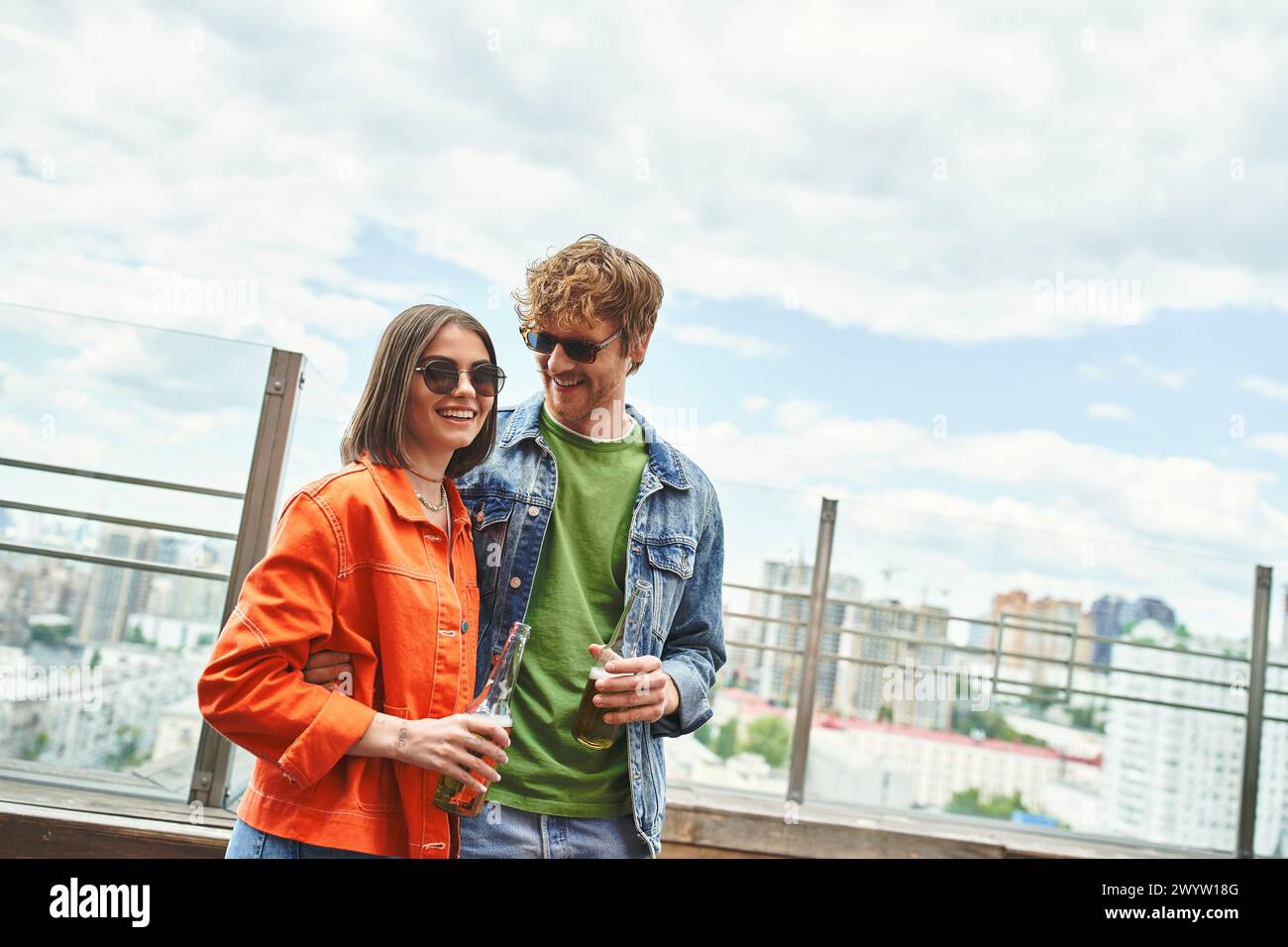 A man and woman standing side by side, gazing into the distance with a ...