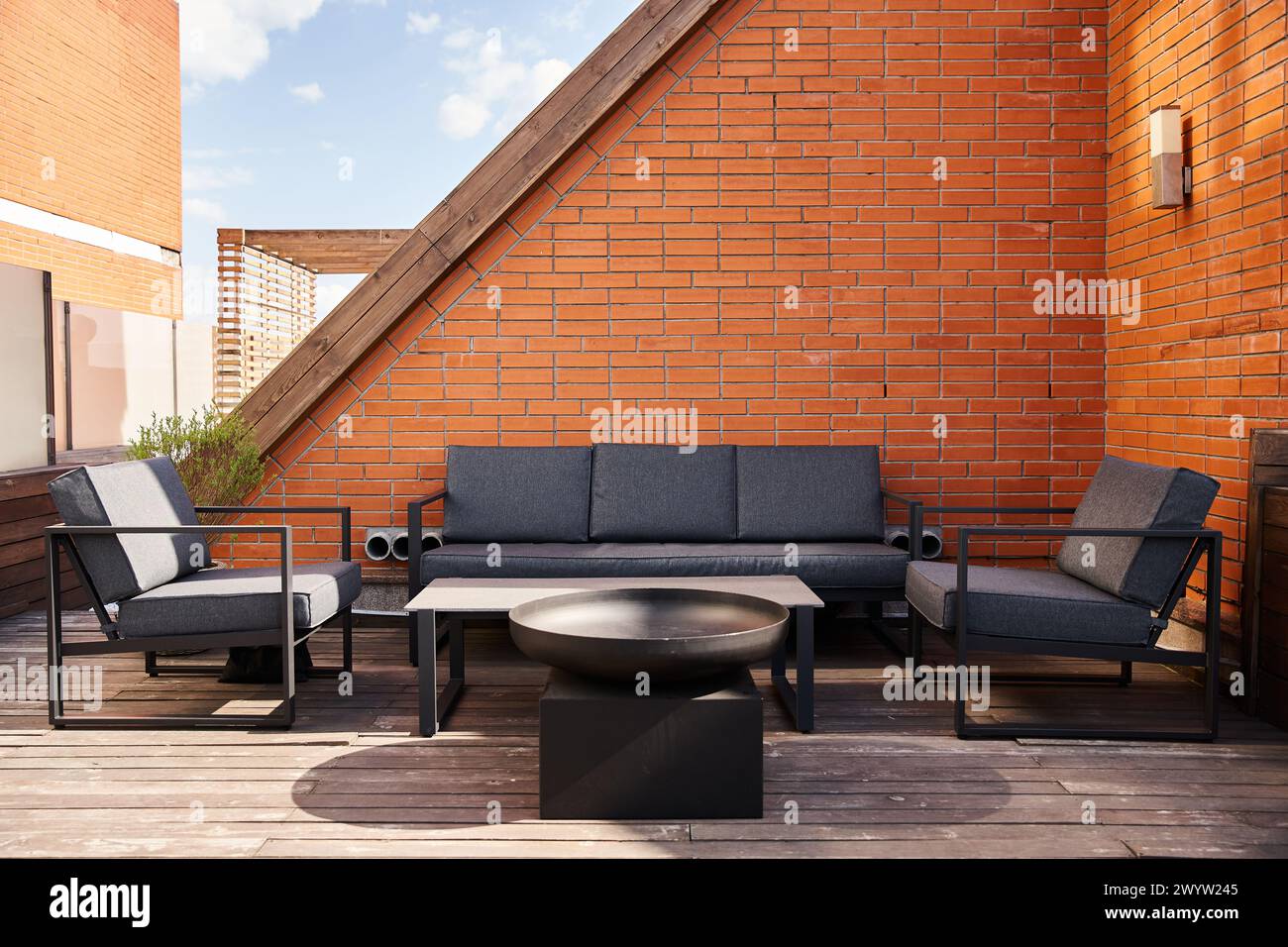 A cozy setup of a couch and chairs on a wooden deck, surrounded by ...