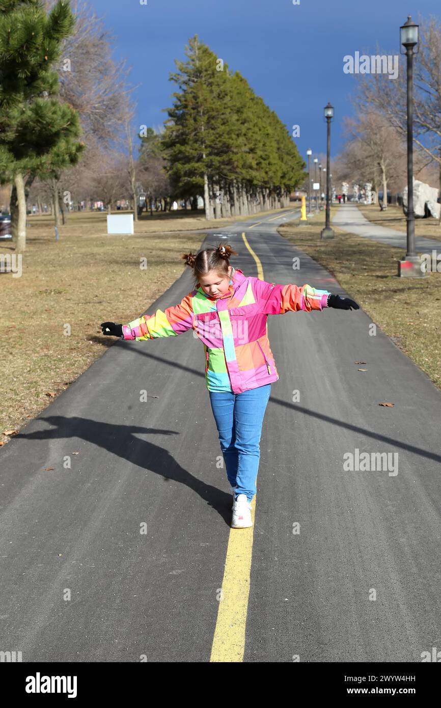 Little girl walking on traffic line Stock Photo - Alamy