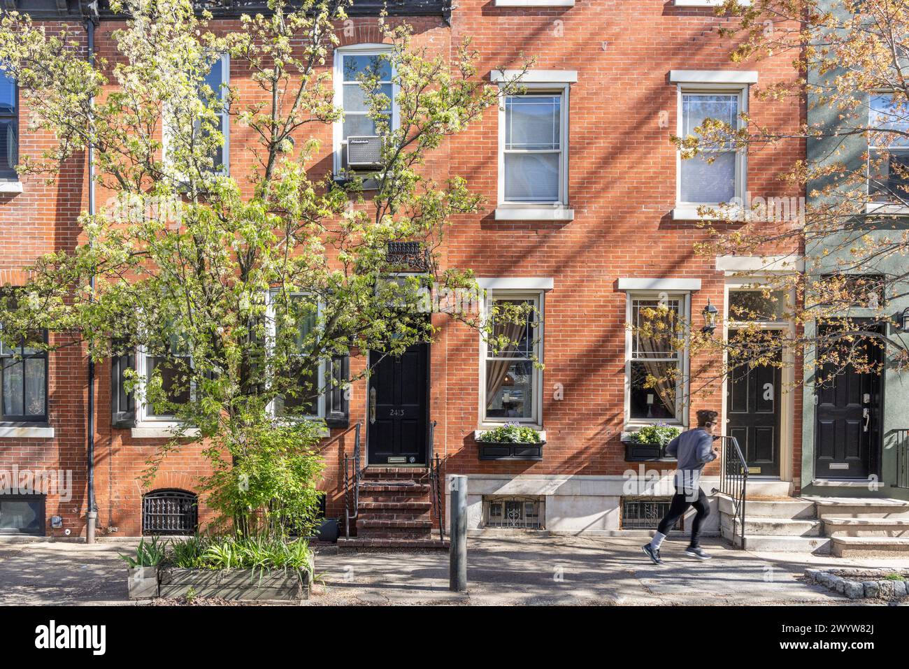 Runner on sidewalk in front of row homes, Fitlers Square neighborhood ...