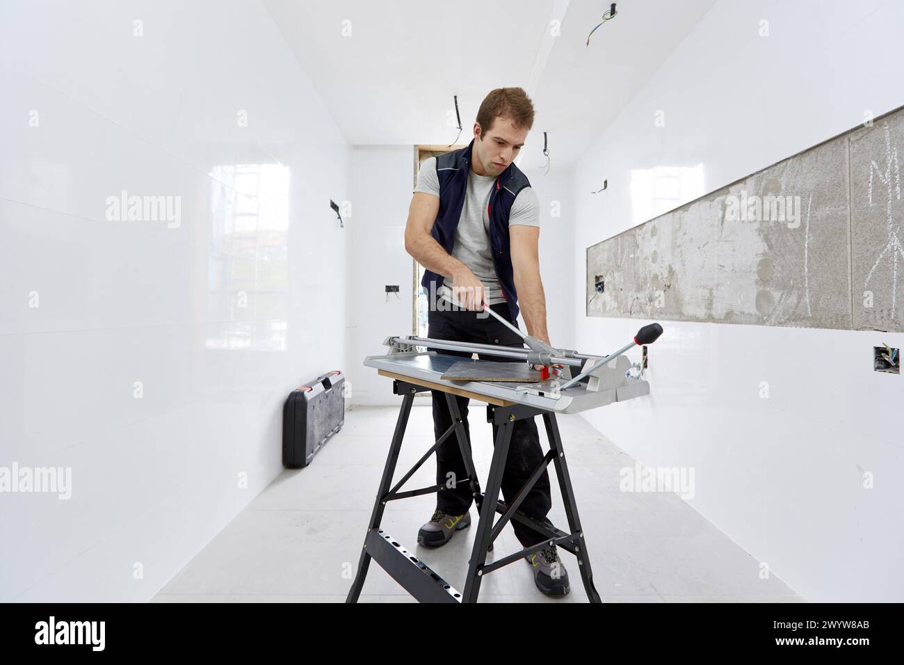 Bricklayer cutting tile. Manual tile cutter. Construction Industry ...