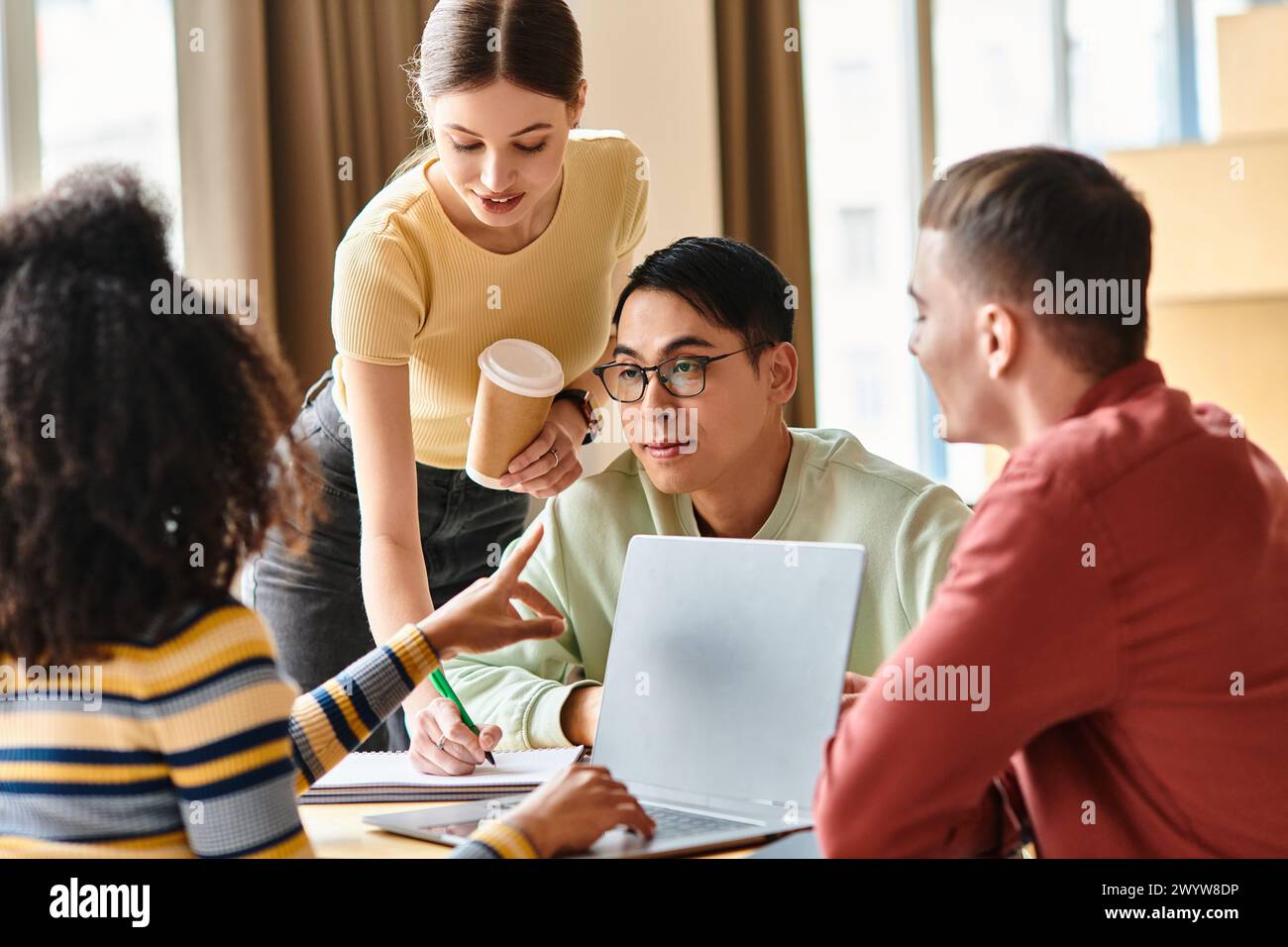 A diverse group of students engage in discussion and work together ...