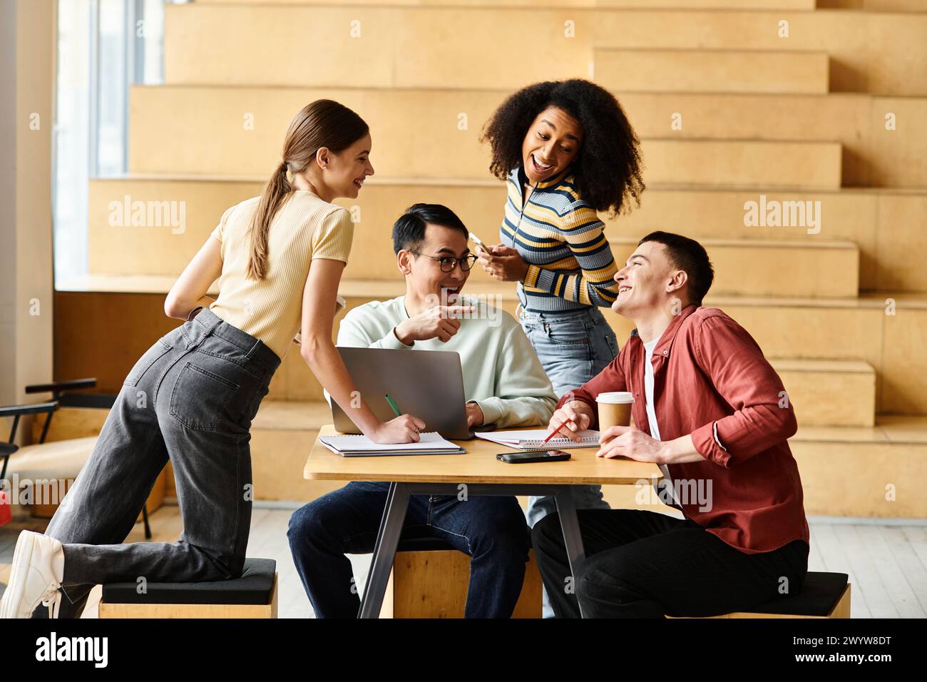 Students of various backgrounds sit together at a wooden table, engaged ...