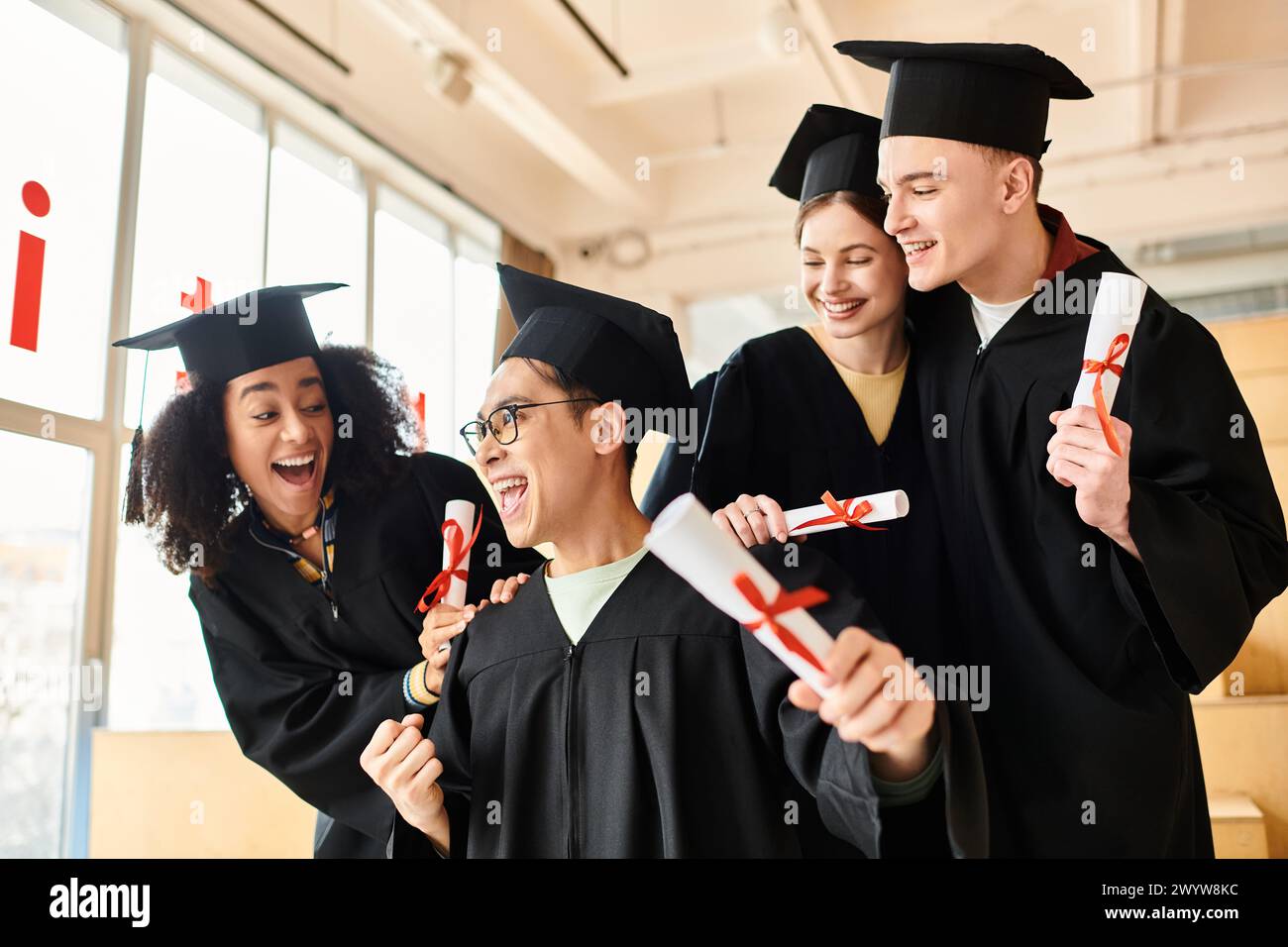 A diverse group of people in graduation gowns, holding diplomas ...