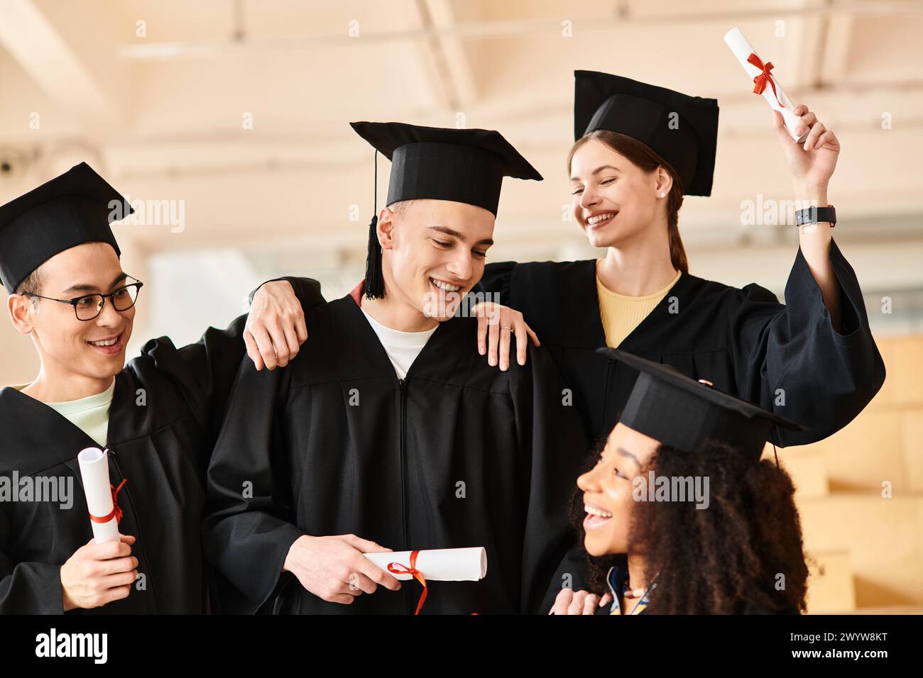 A varied group of students in graduation gowns and caps posing happily ...