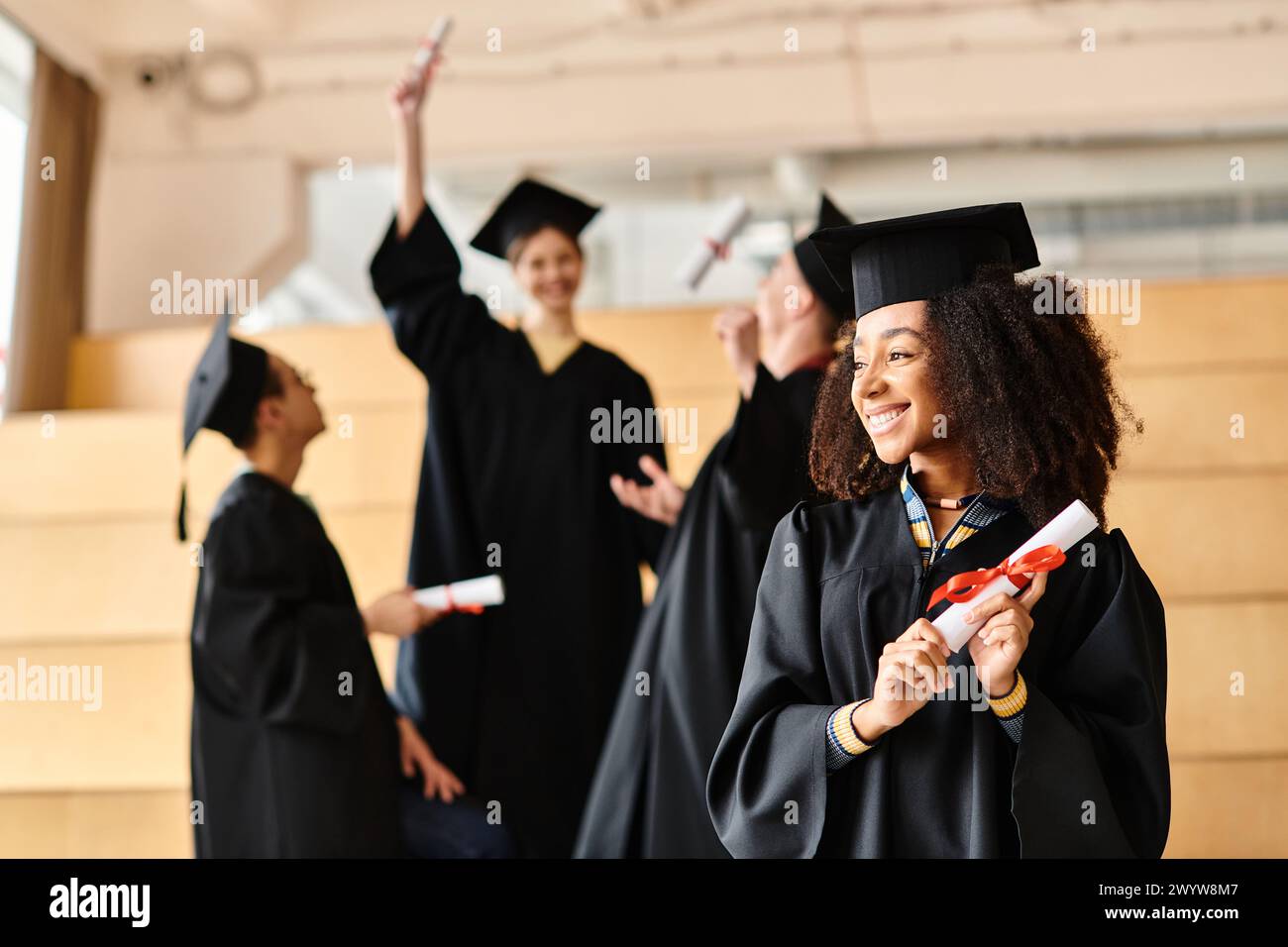 A diverse group of students in graduation gowns and mortarboards ...