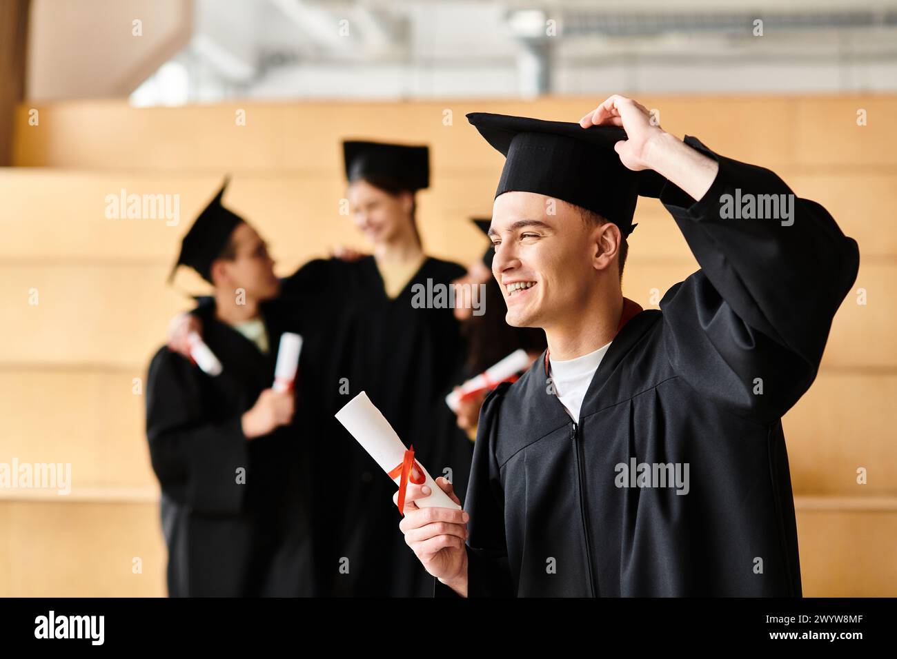 A diverse man, clad in a graduation cap and gown, proudly holds a ...