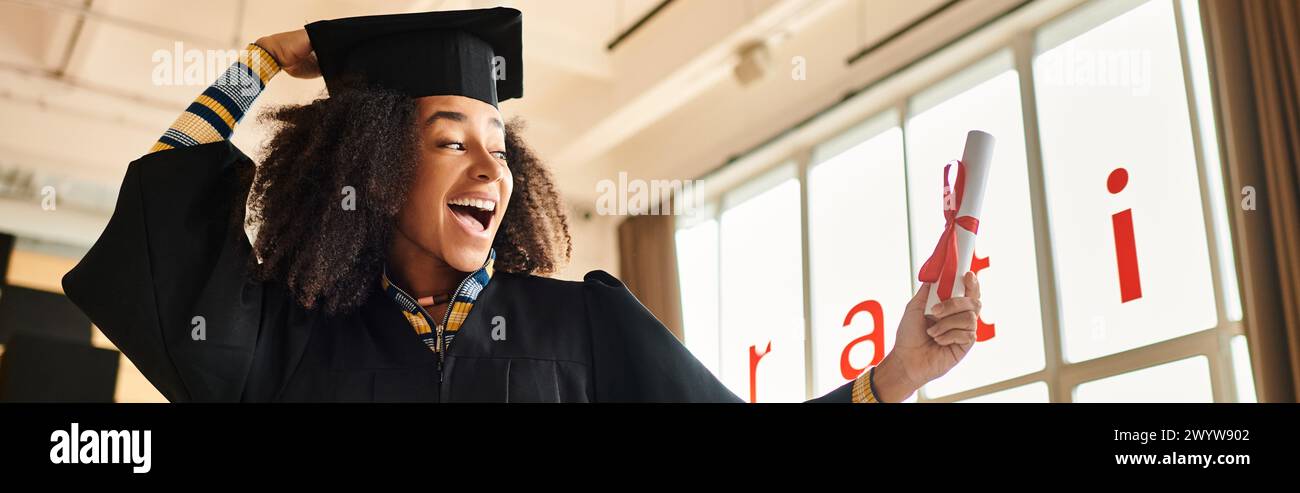African American student proudly wears graduation cap and gown ...