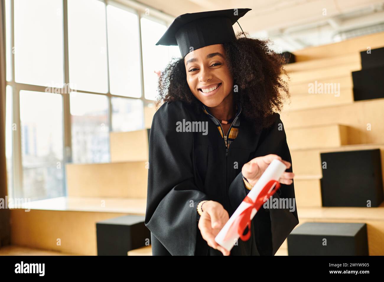 An African American woman in a graduation cap and gown celebrating ...