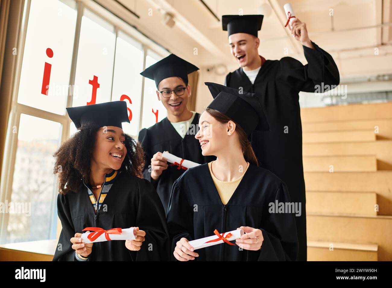 A group of diverse students in graduation gowns holding diplomas ...