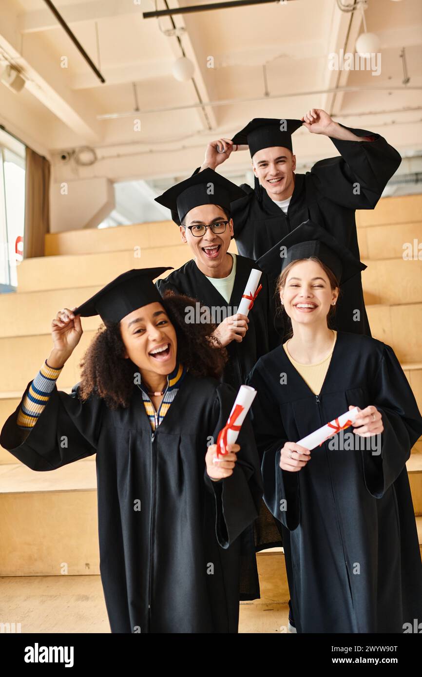 Diverse group of students in graduation gowns and caps smiling for a ...