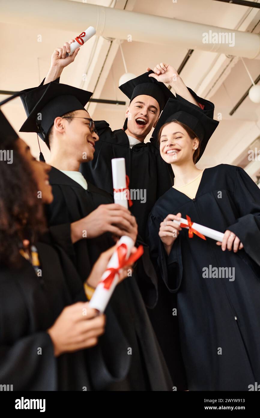 A group of diverse students in graduation gowns and caps stand together ...