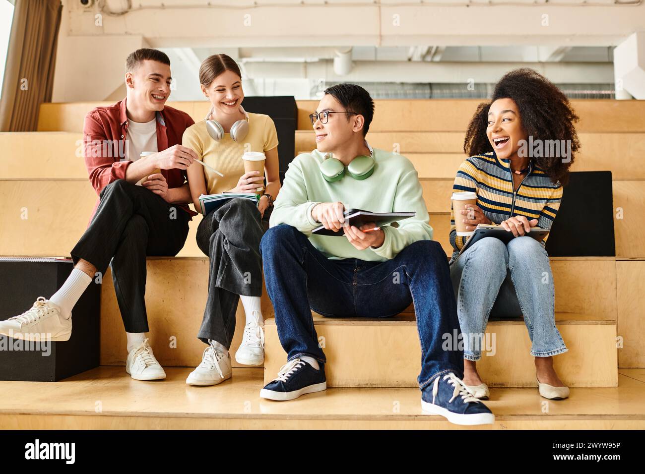 Multicultural students of various backgrounds gather on steps, engaged ...
