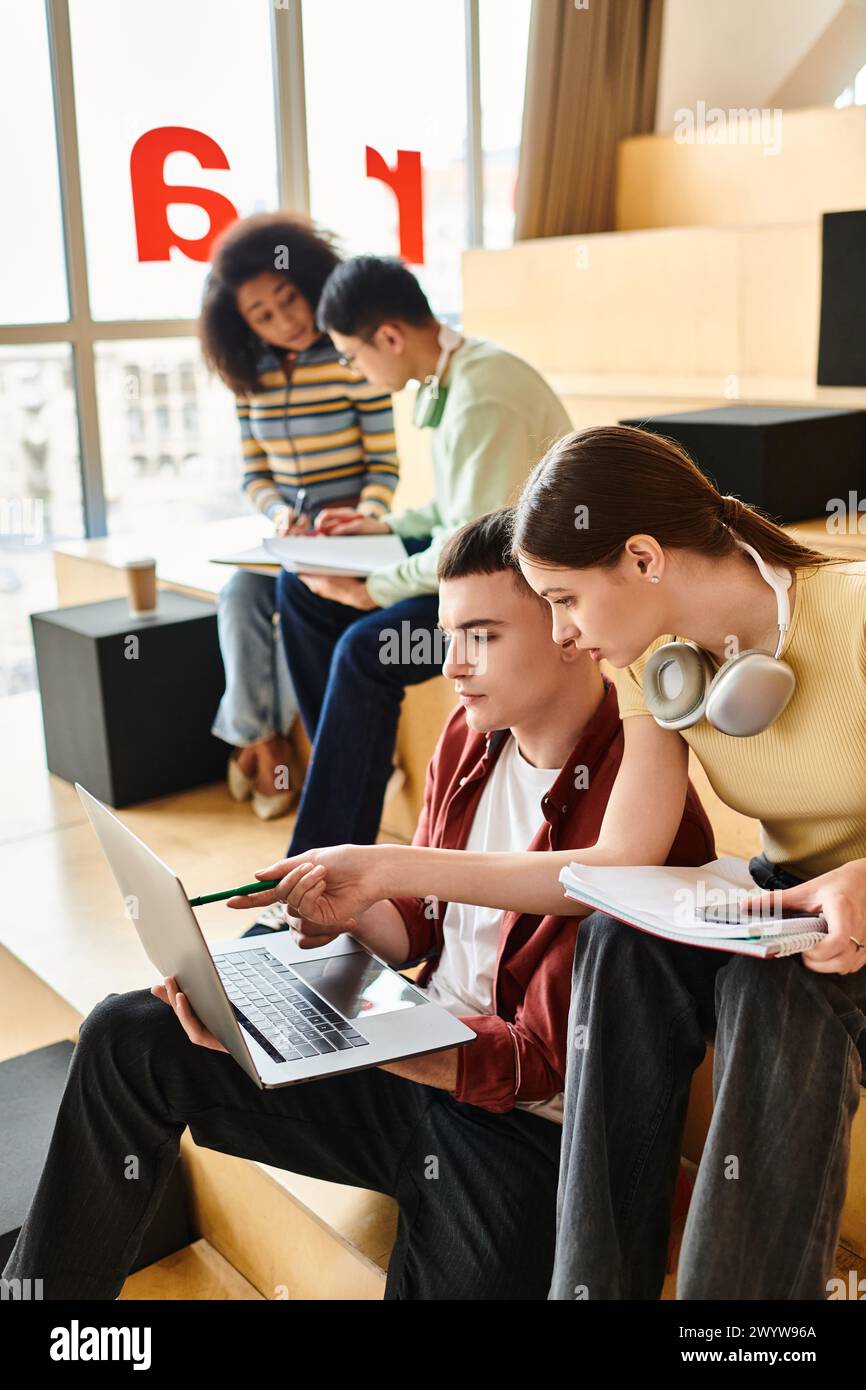 Multicultural group of students seated on bench, engrossed in laptops ...