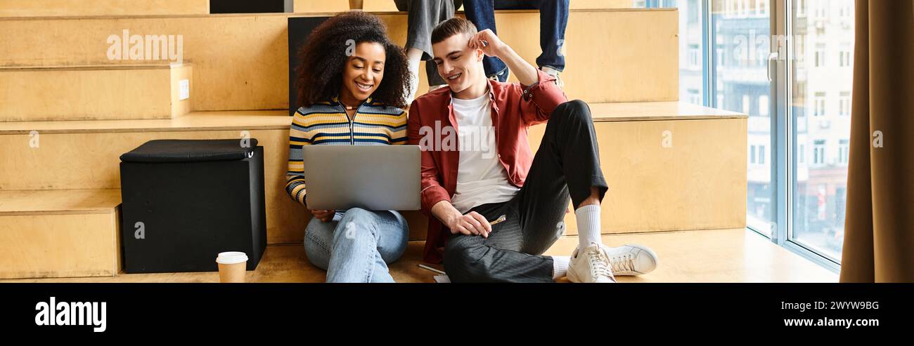 A man and a woman of differing ethnic backgrounds sit on stairs ...