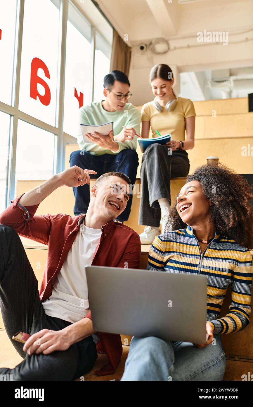 Multicultural group of students collaborating around a laptop for ...