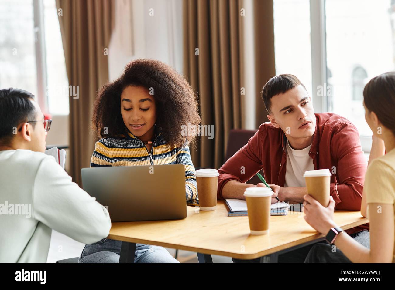 A multicultural group of students engage in a lively discussion around ...