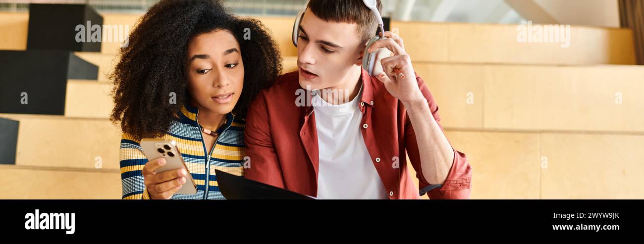 A diverse pair, one African American girl, engaged with a cell phone ...