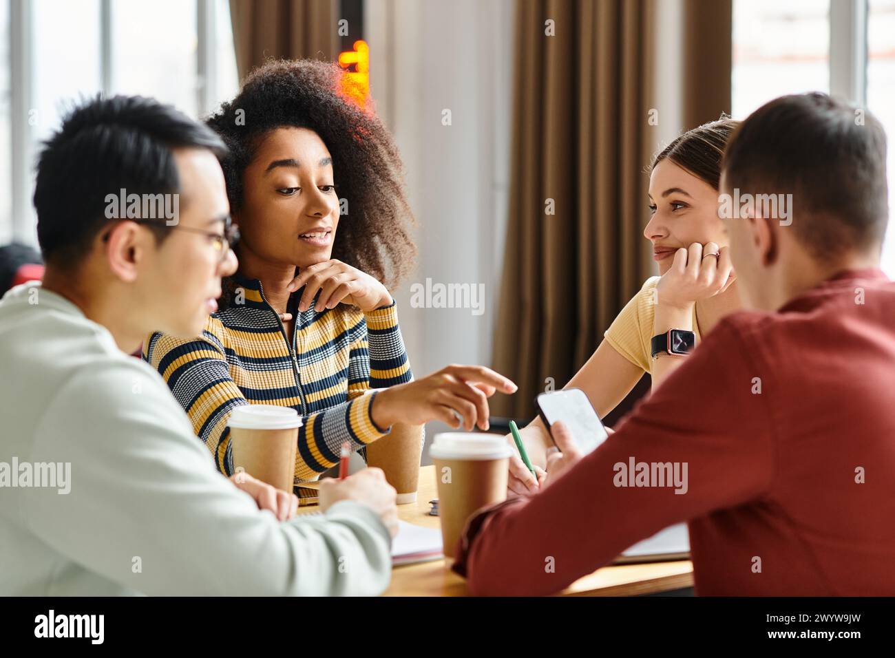 A diverse group of students from different backgrounds sit together ...