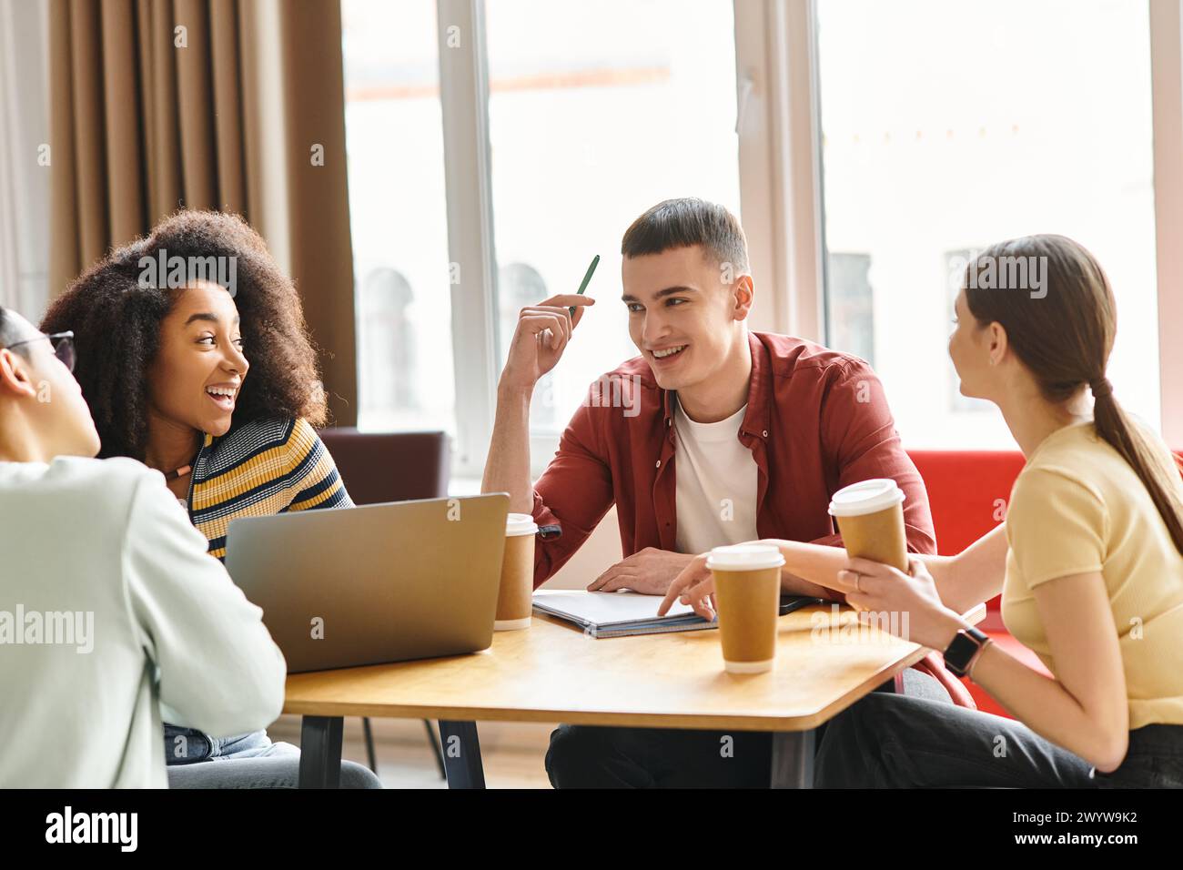 A diverse group of students engaged in animated conversation around a ...