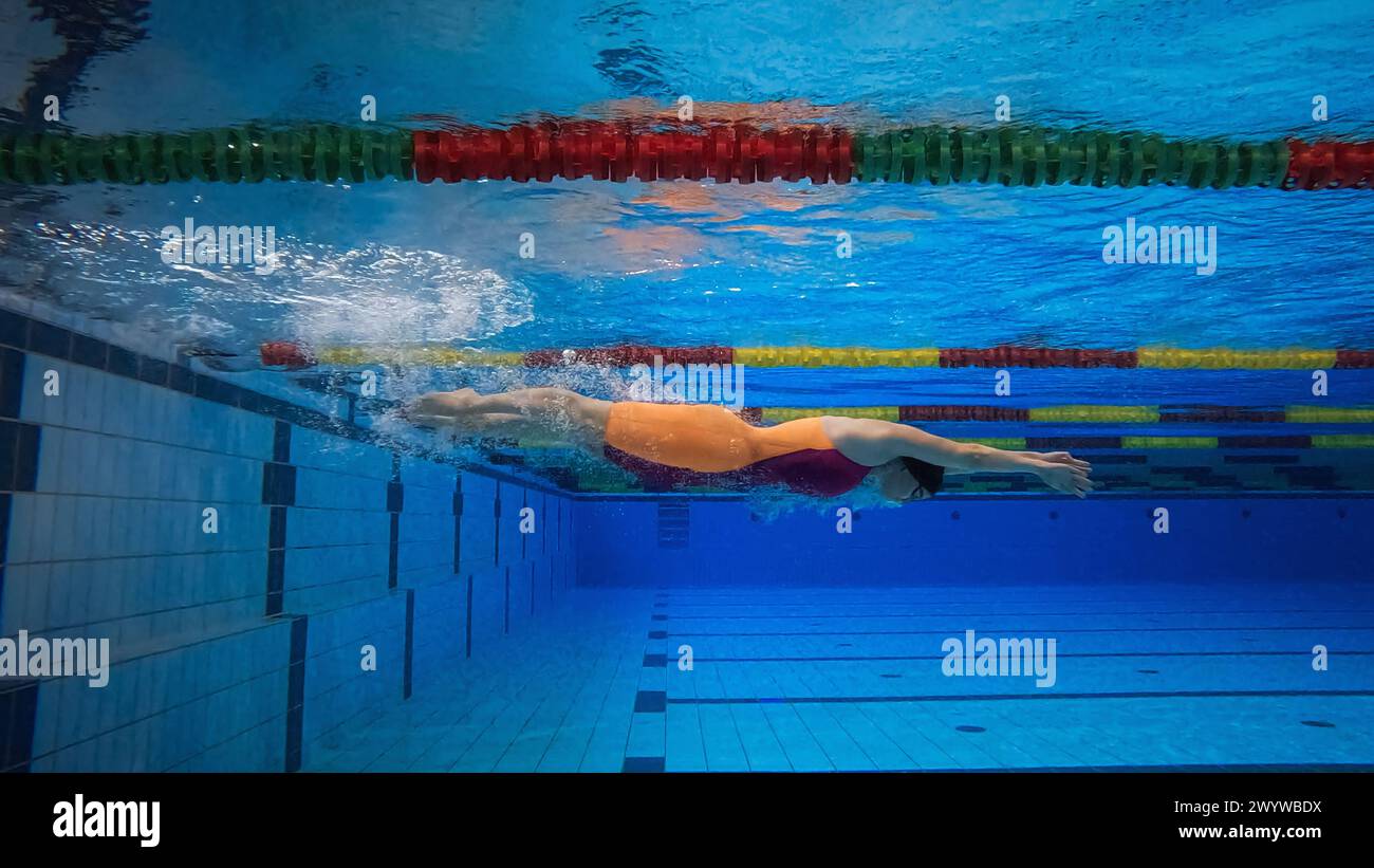 Female athlete swimming in the freestyle and making a flip turn to ...