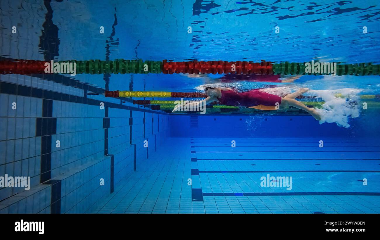 Female athlete swimming in the freestyle and making a flip turn to ...