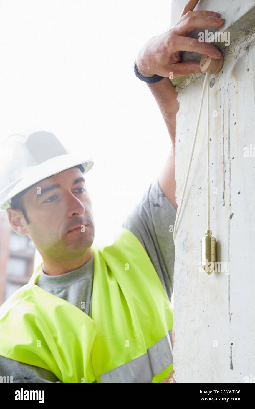Worker with protective equipment, PPE, Checking and aligning vertical ...