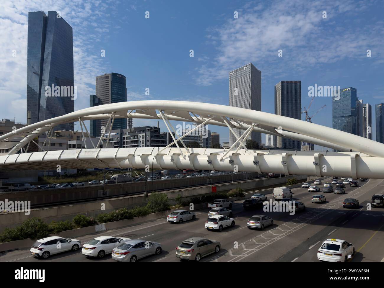 Cars and a train passing under Yehudit Bridge, a bicycle and pedestrian ...