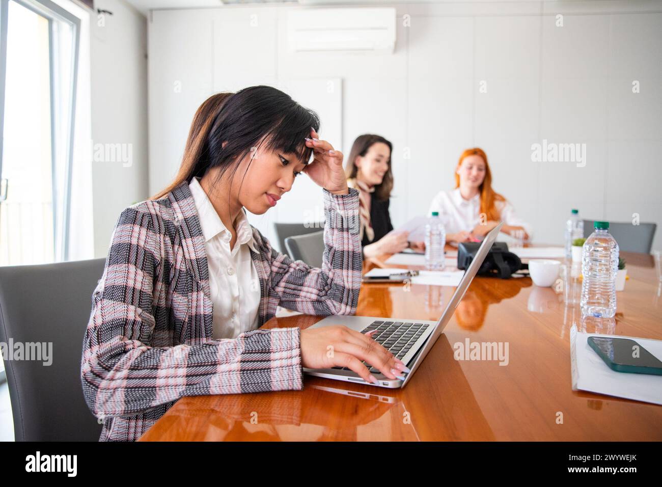 A businesswoman is stressed during work, she touches her forehead in ...
