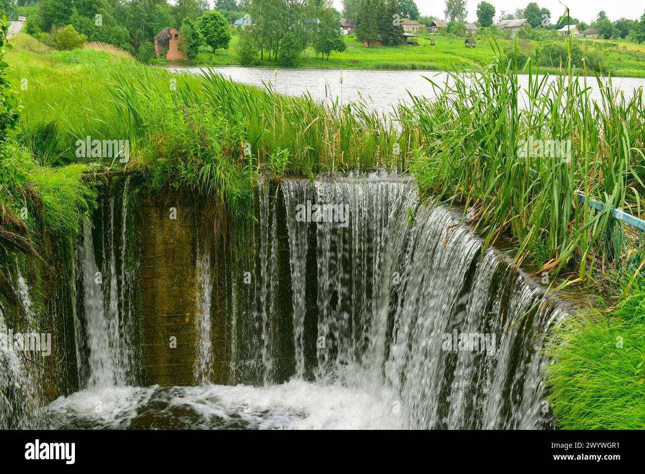 Streams of water flow out of the lake. Dam. Lake drainage Stock Photo ...