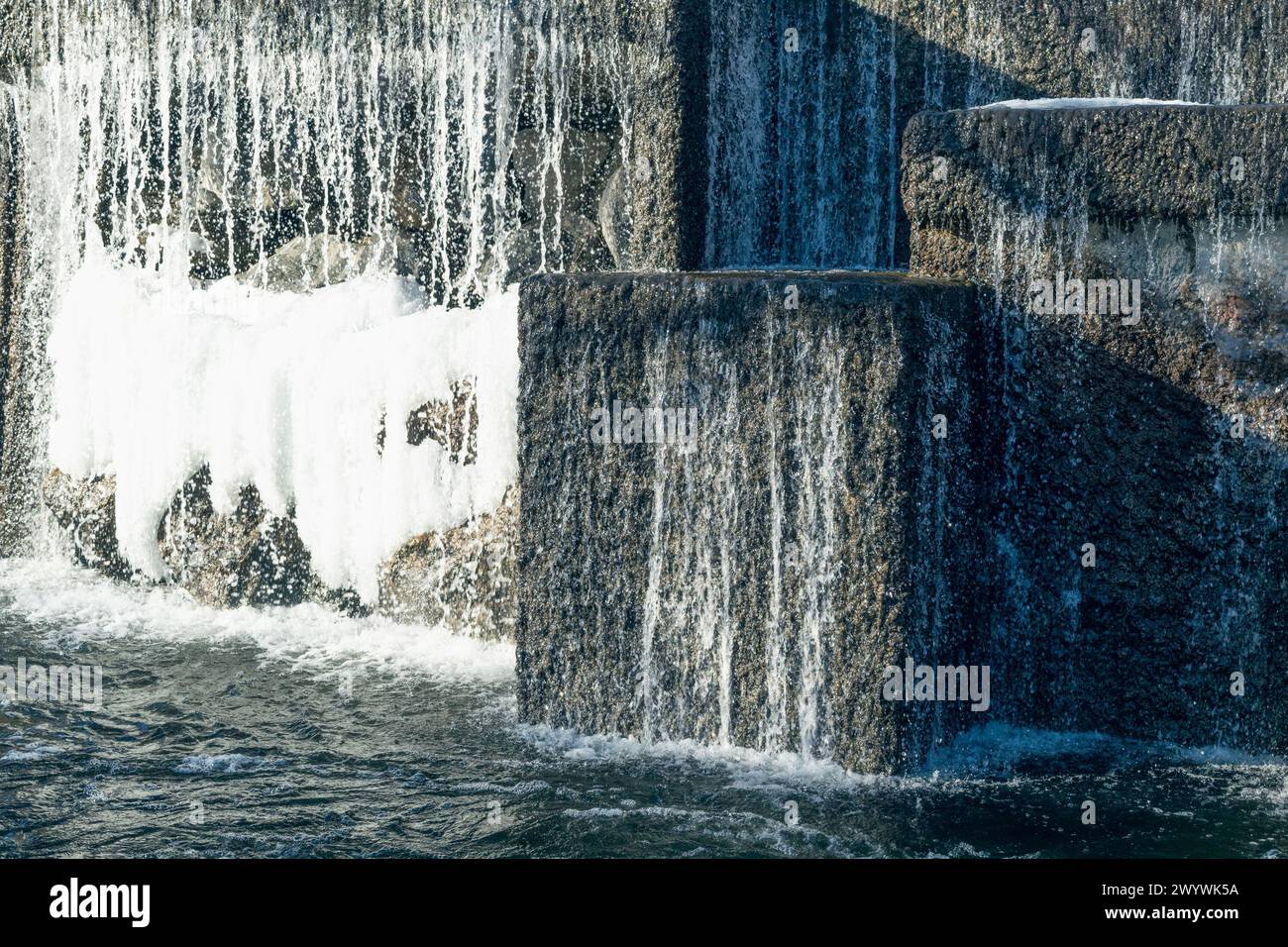 Artificial waterfall in the park. Streams of water, splashes and foam ...