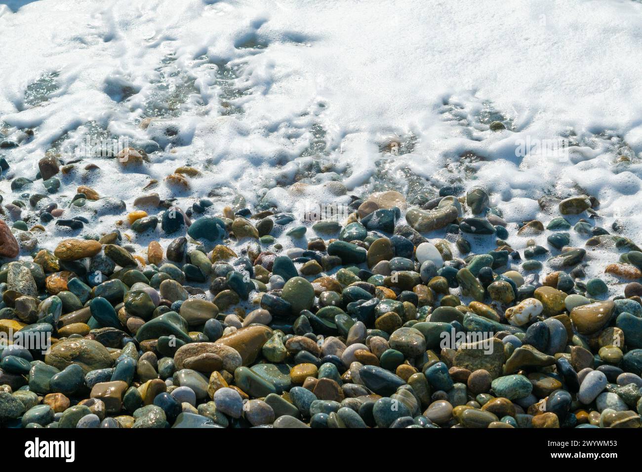 Sea pebbles and sea foam. Rocky seashore. Natural backgrounds and ...