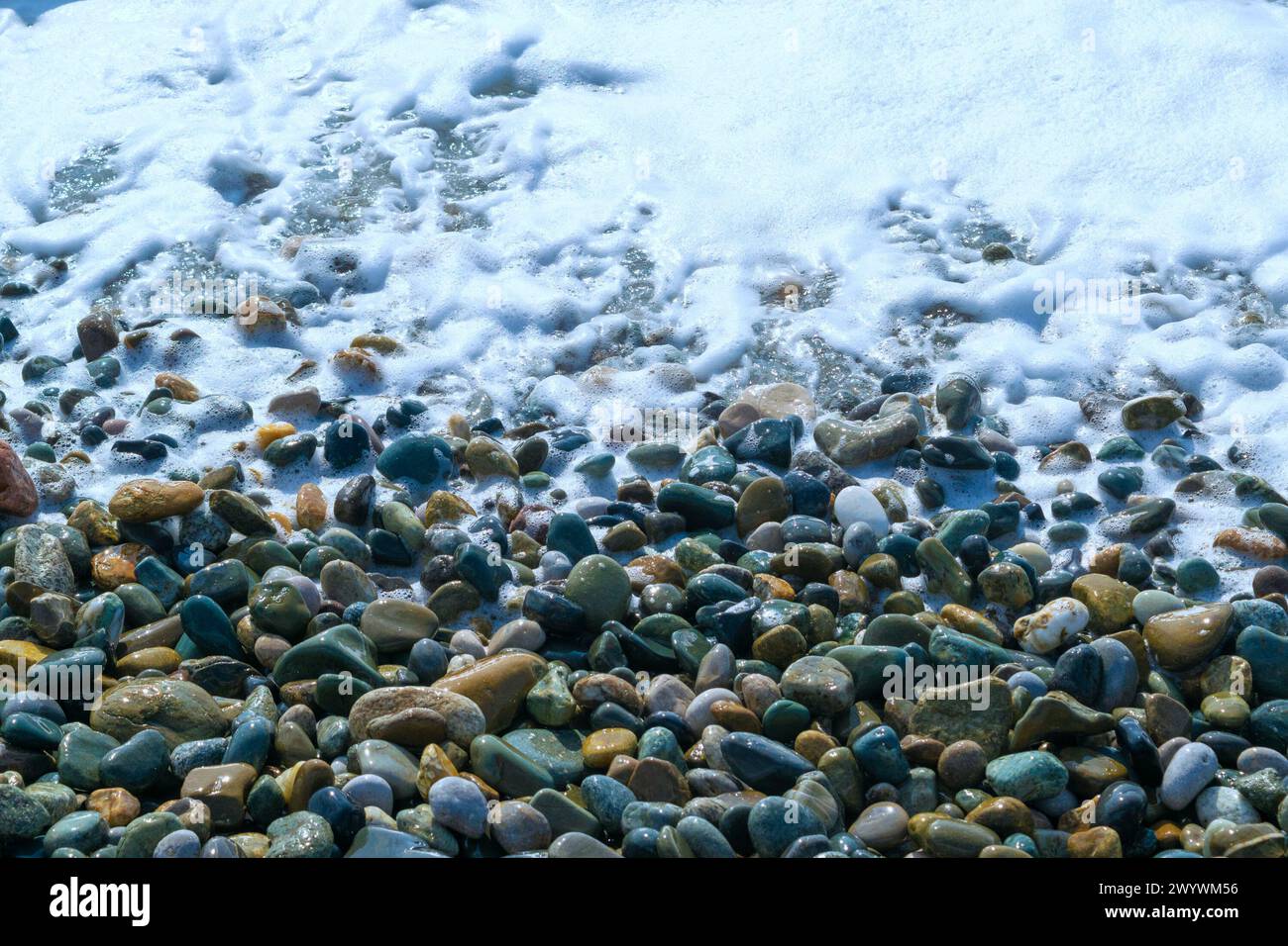 Sea pebbles and sea foam. Rocky seashore. Natural backgrounds and ...