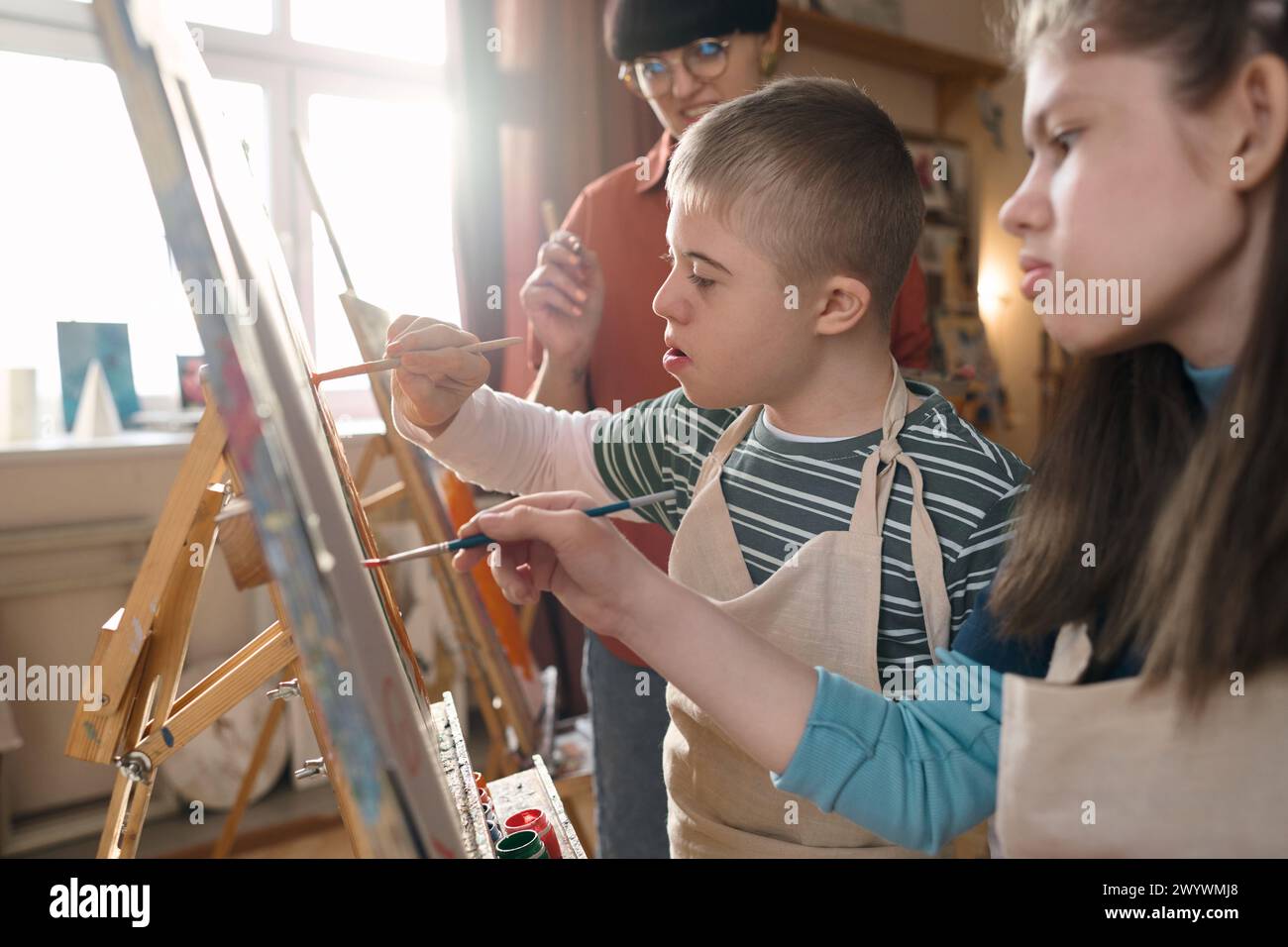 Side view portrait of children with disability painting together ...