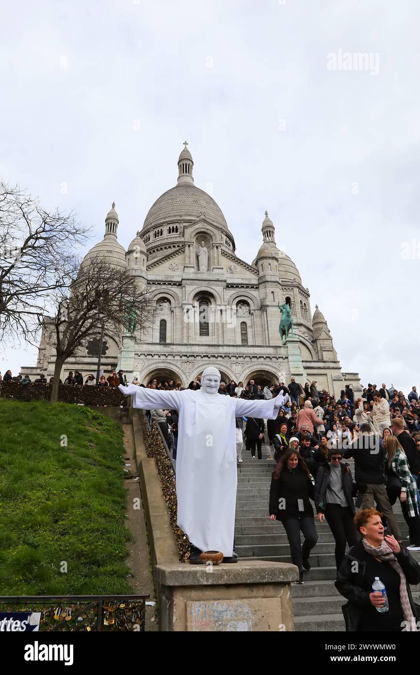 Painted mime perform artist showing white frozen statue in front of ...