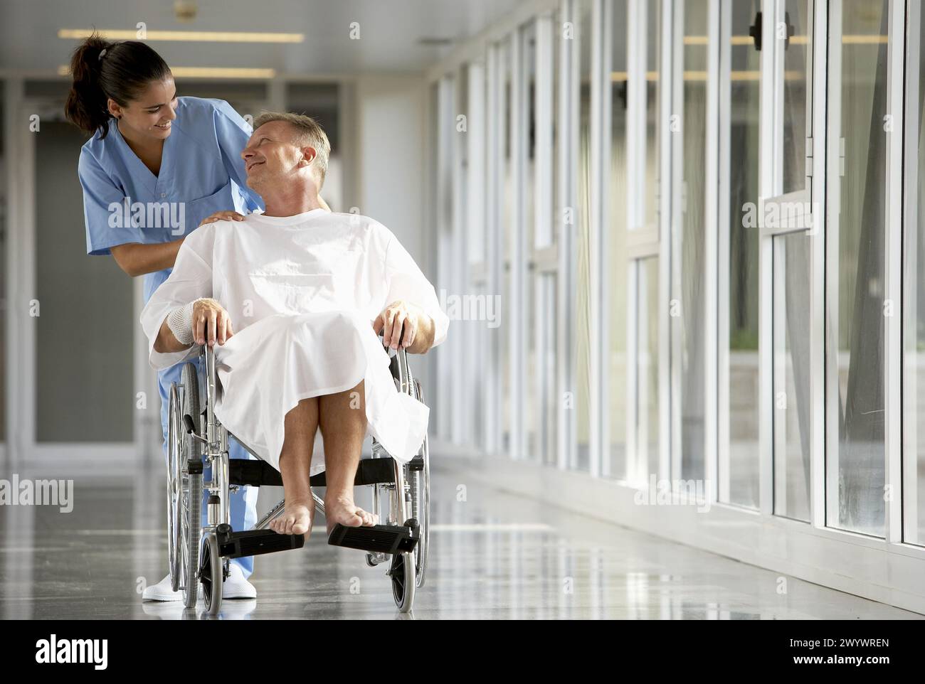 Nurse pushing patient in wheelchair Stock Photo - Alamy