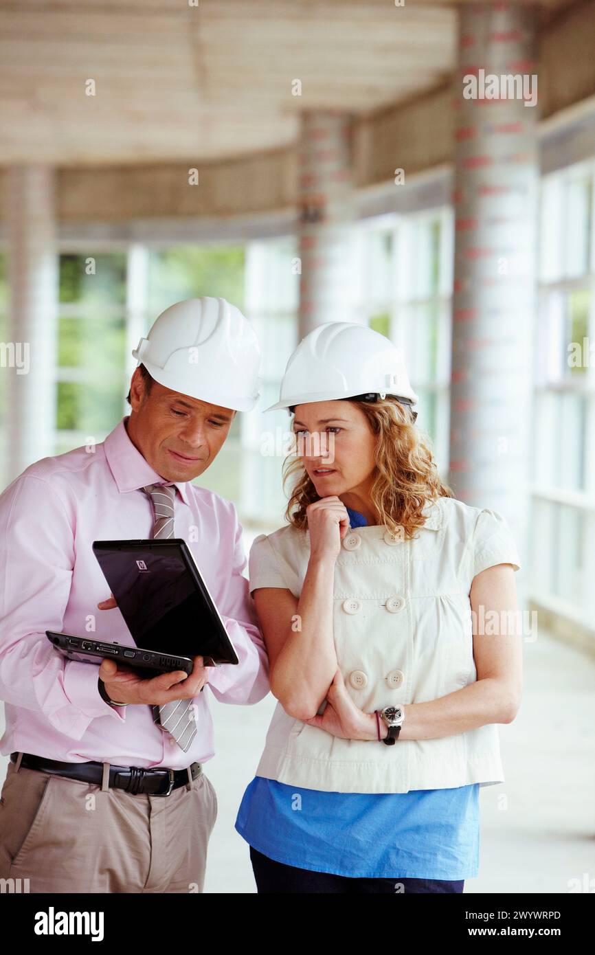 Architect and client with tablet PC in construction site Stock Photo ...