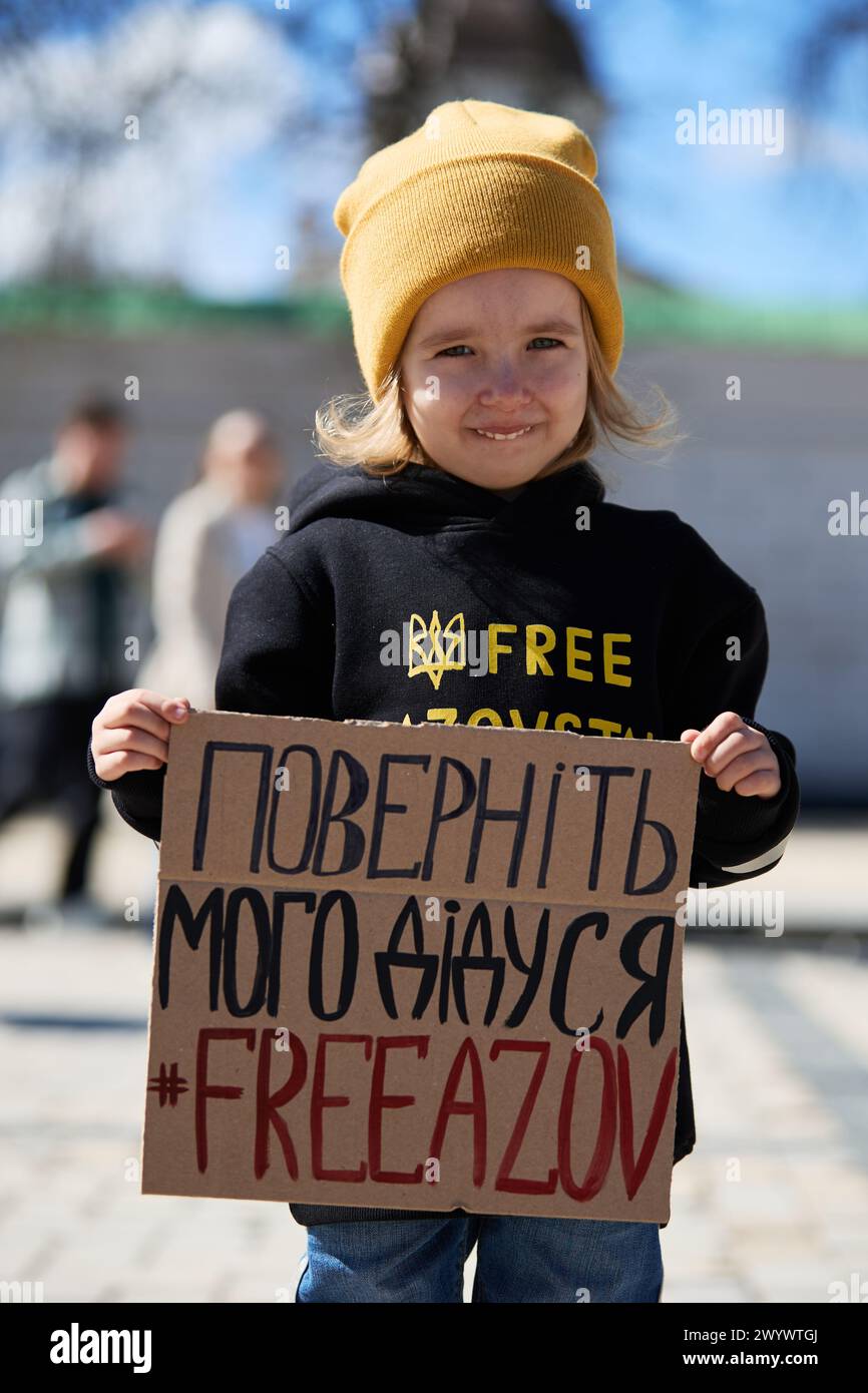 Little Ukrainian girl posing with a banner "Bring My Grandfather Home ...