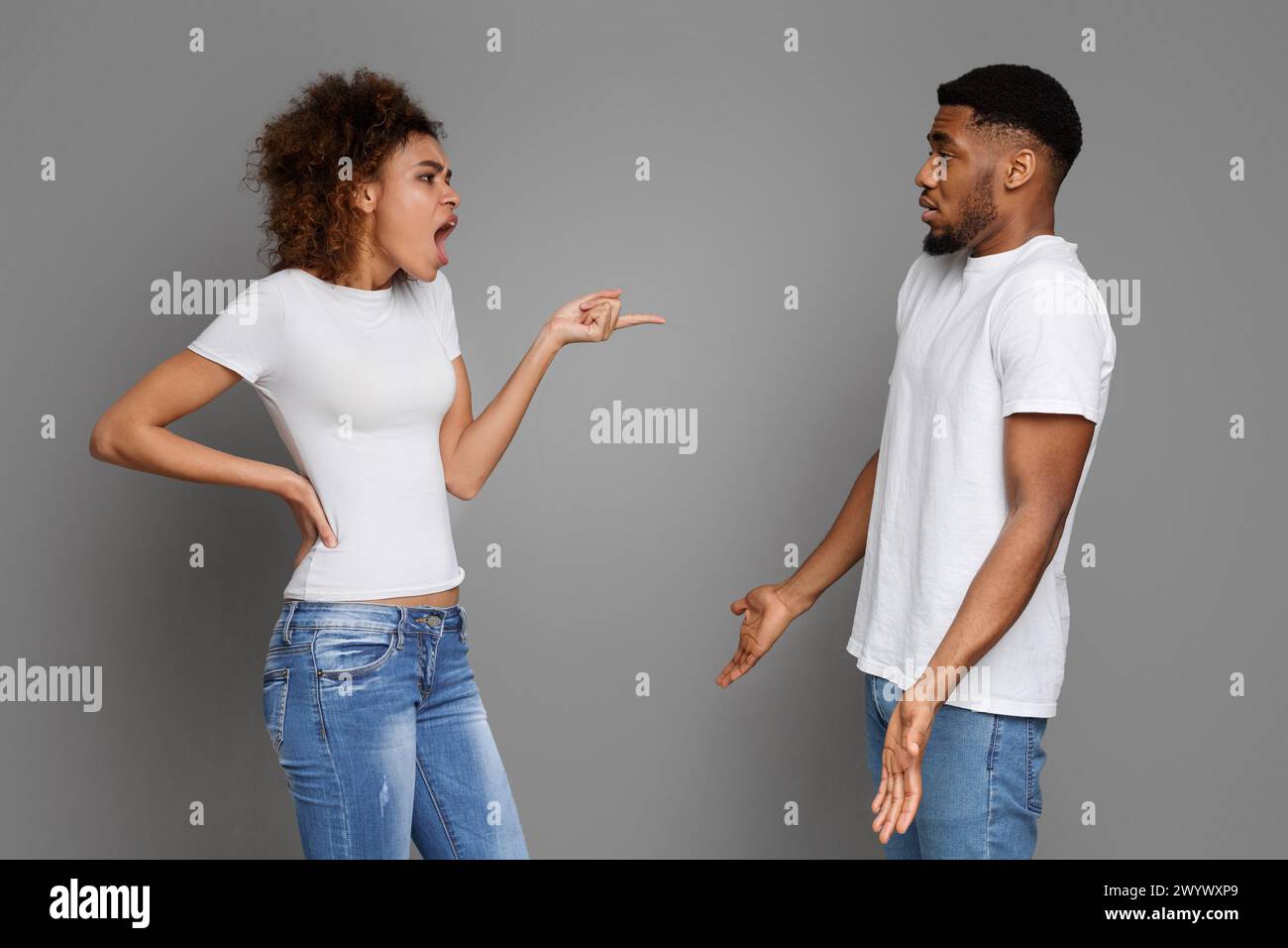 Angry woman standing and blaming at unhappy man Stock Photo - Alamy