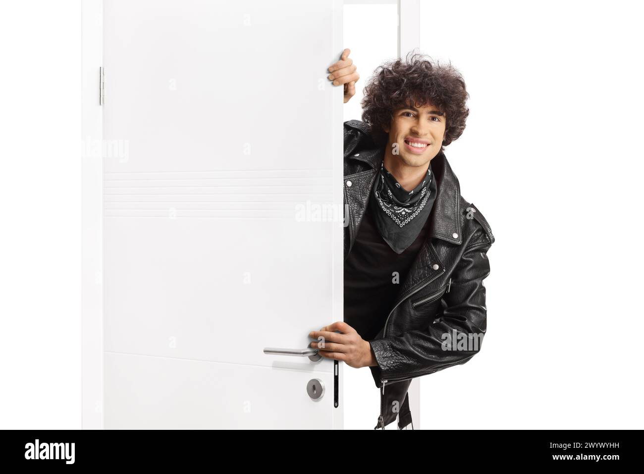 Guy in a black leather jacket standing behind a door isolated on white ...