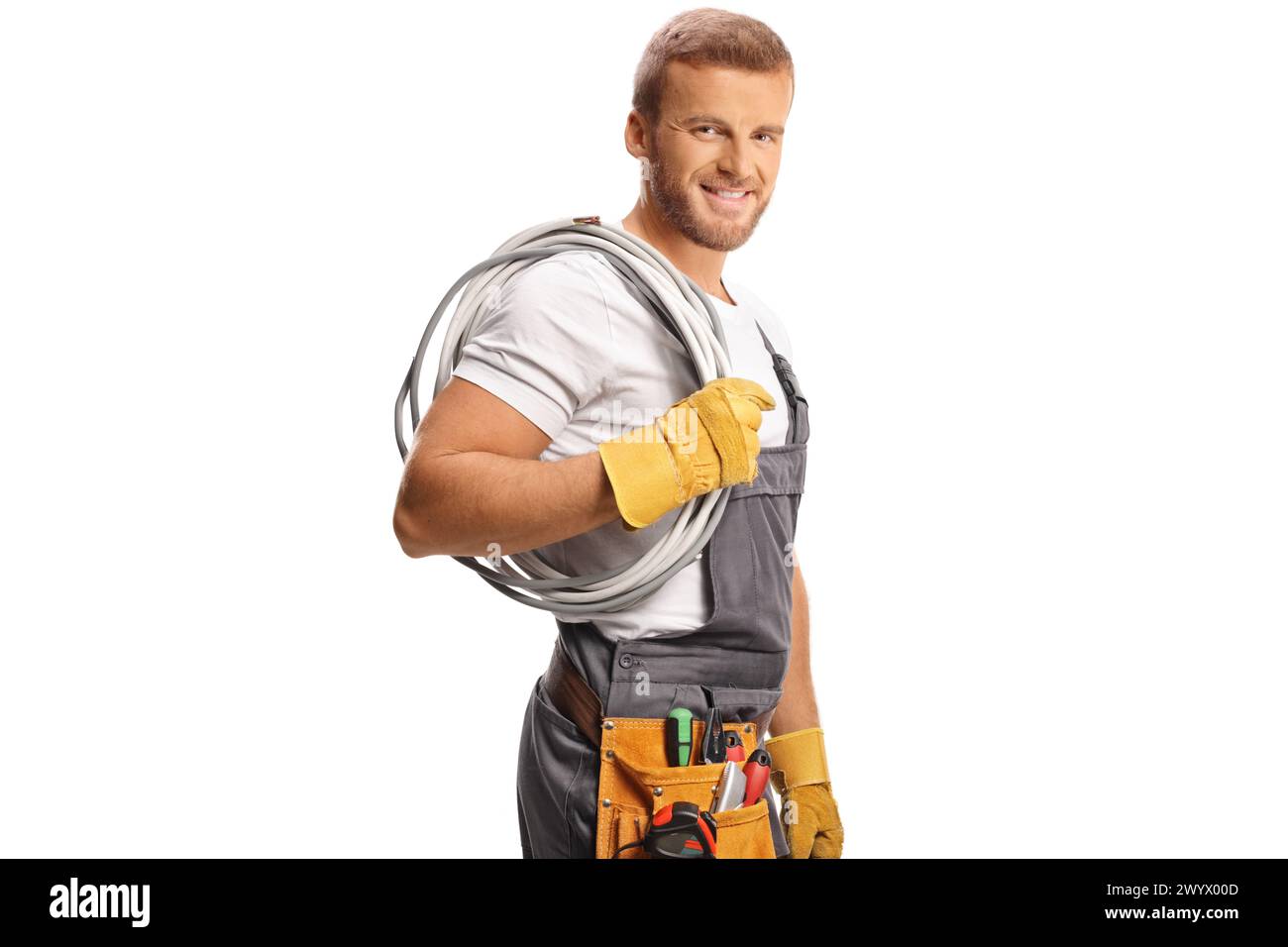 Electrician with a tool belt carrying cables on his shoulder isolated ...