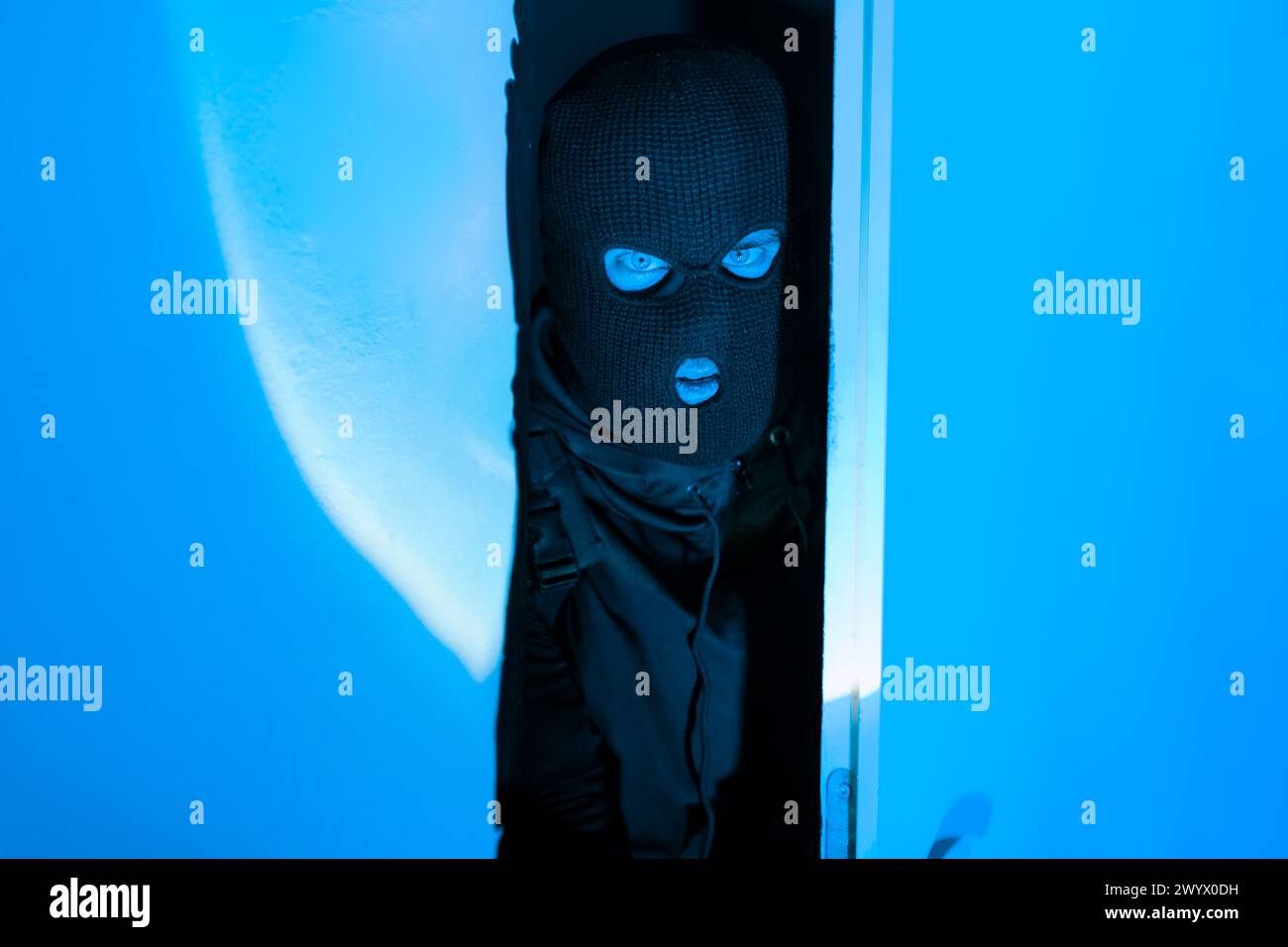 Masked intruder man peeking inside room suspiciously Stock Photo - Alamy