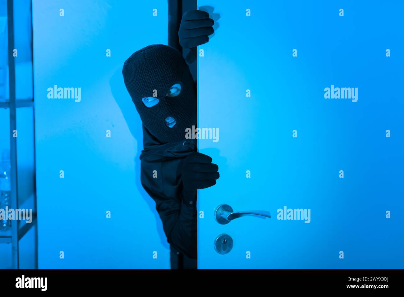 Sneaky burglar man opening a door cautiously Stock Photo - Alamy